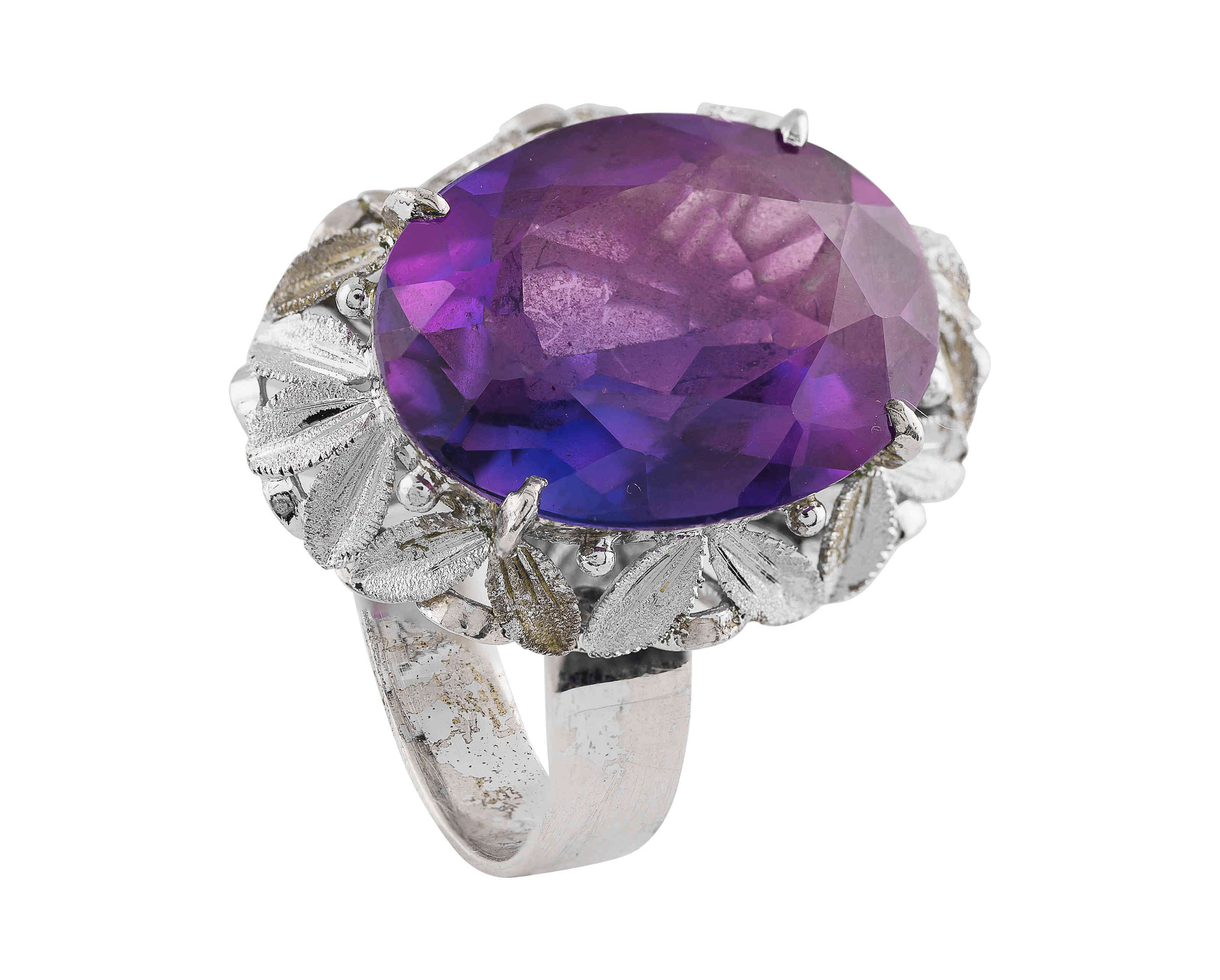 A ring with a large violet stone, possibly amethyst, set in white gold