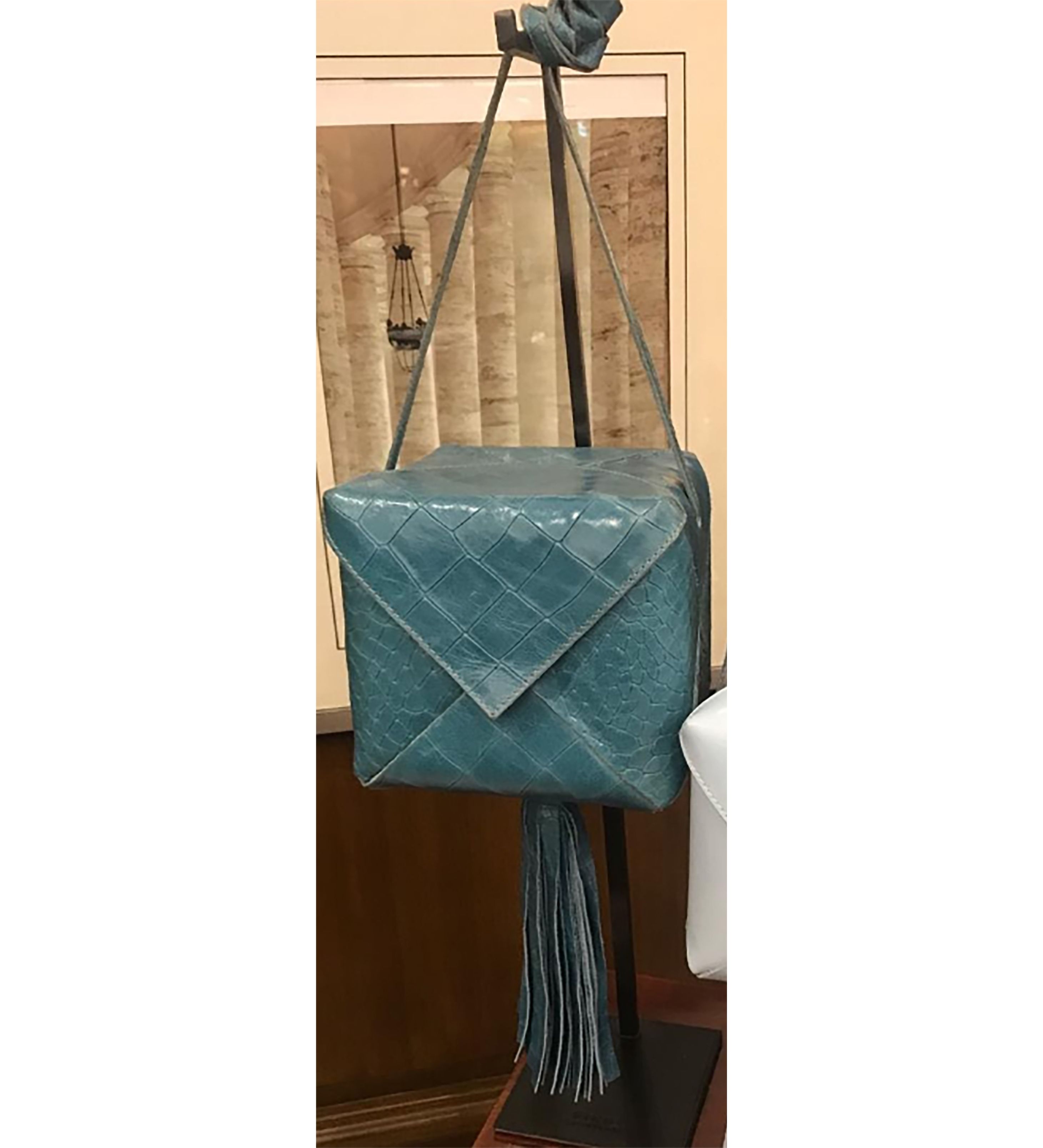 FINO - A teal 'sipa' sling bag in crocodile embossed Italian leather