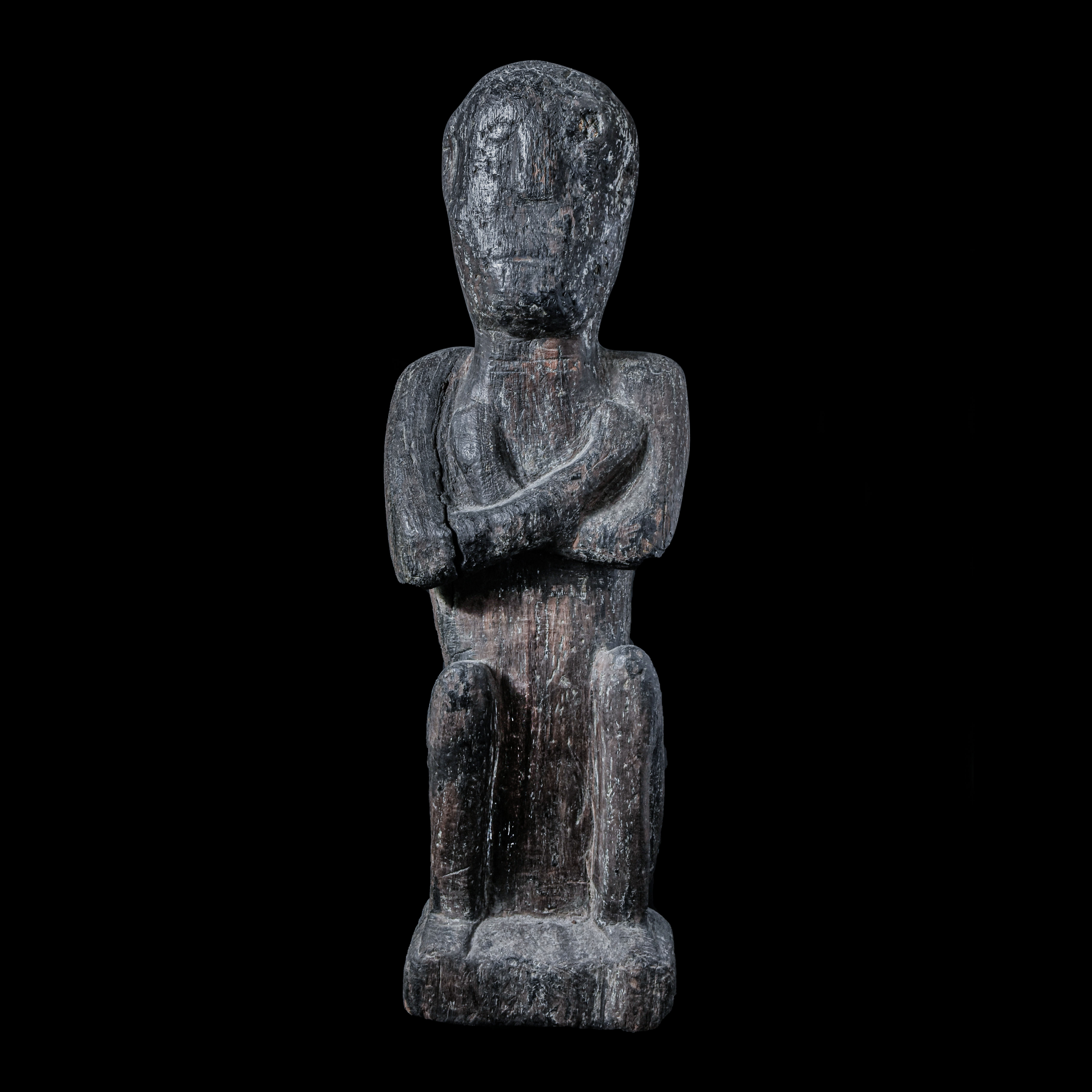 - A seated figure with primitive face