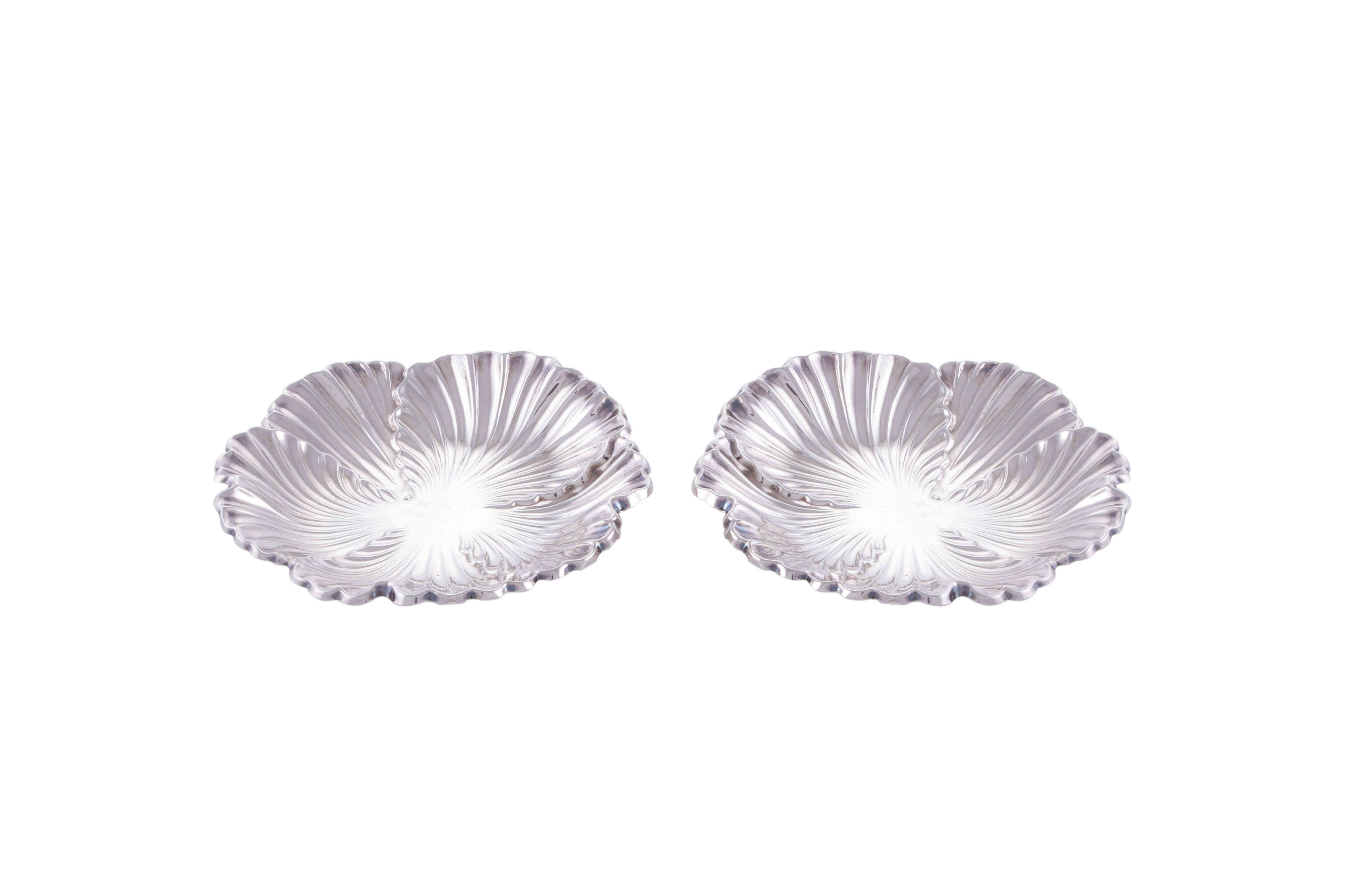 A pair of sterling silver shell coasters